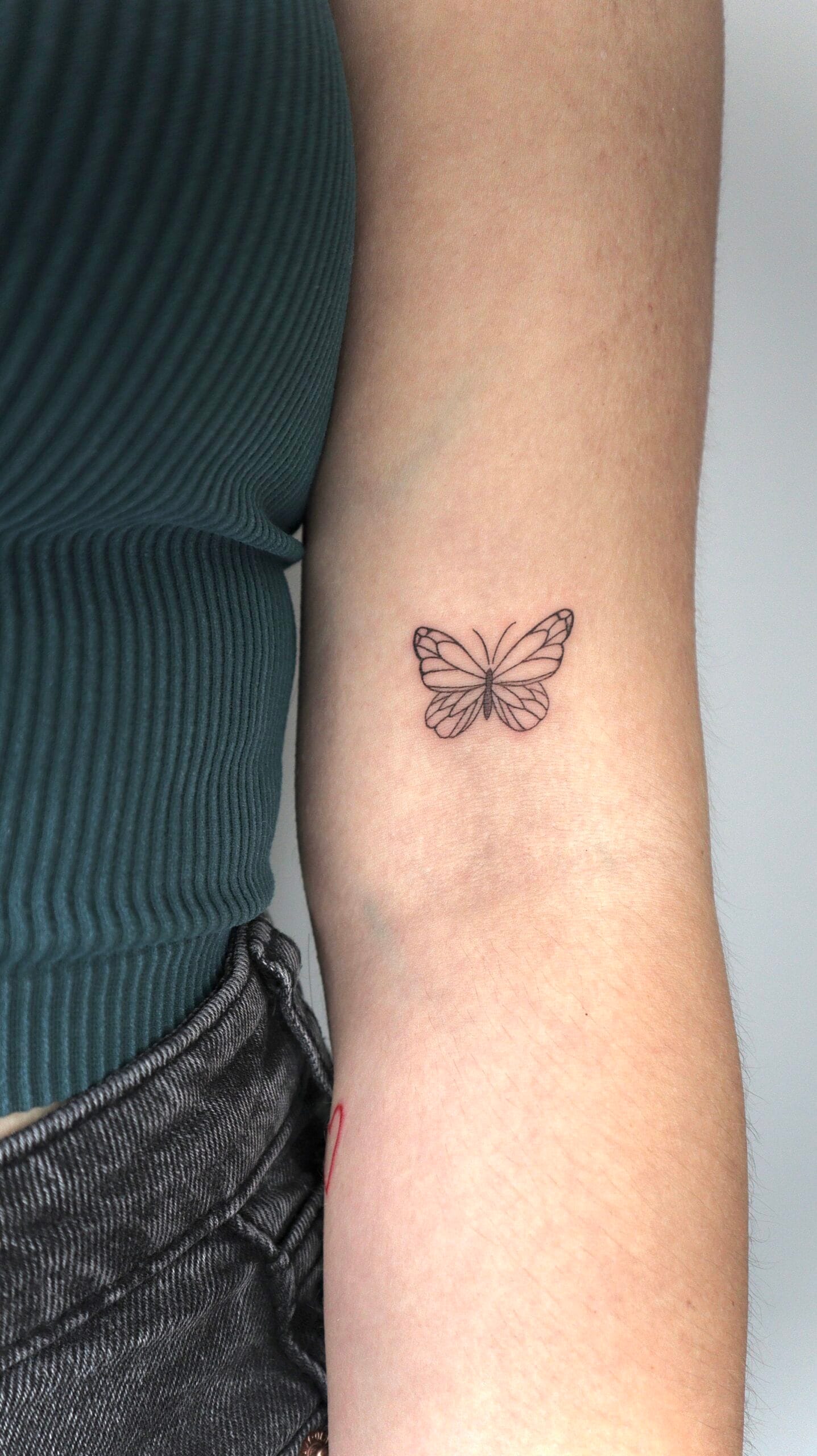 Tiny Butterfly Tattoo in Fine Line Above Elbow Pit - Best tattoo shop ...